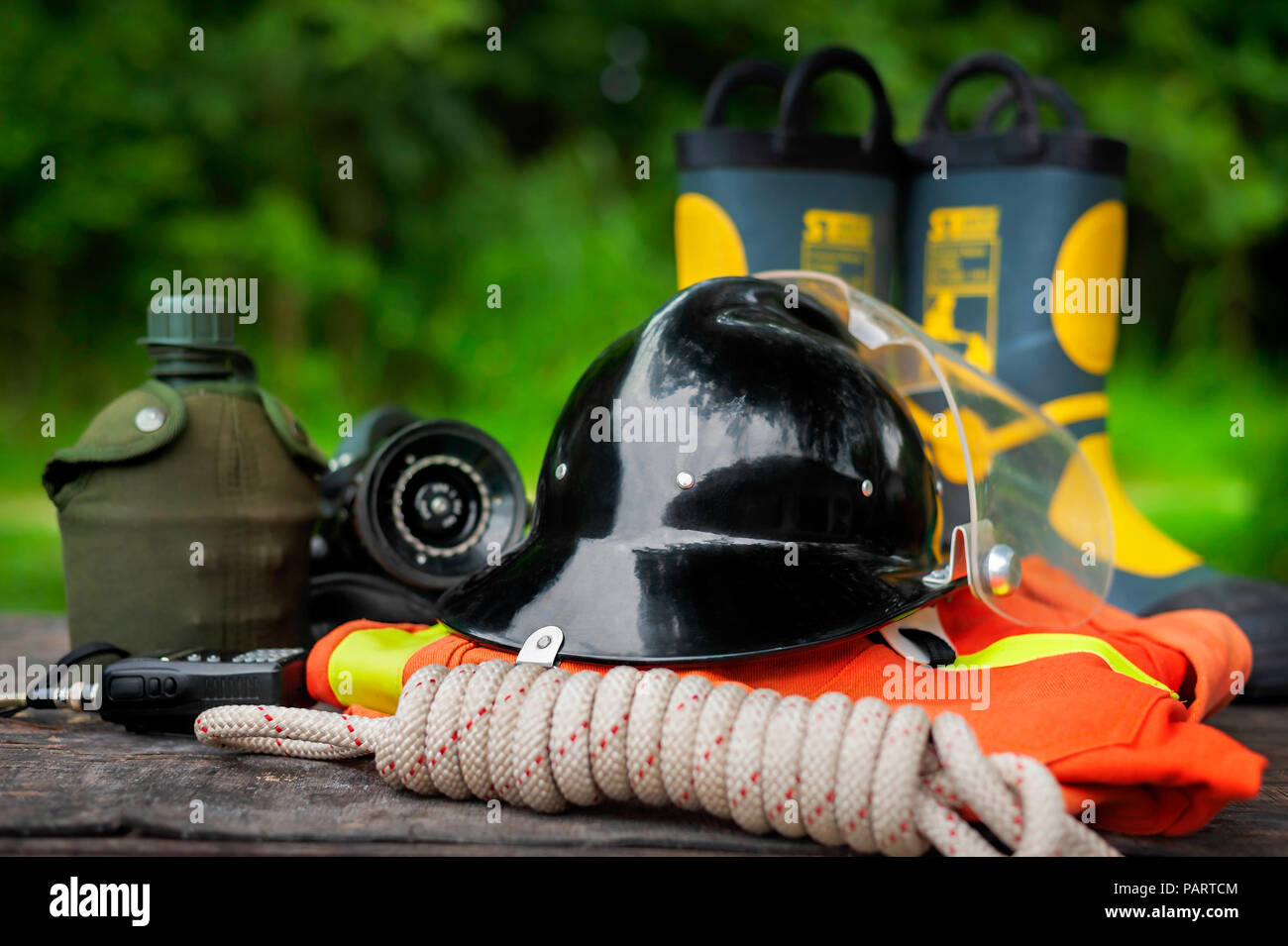 Outfit of Firefighter placed on wooden table background, Fire equipment ...