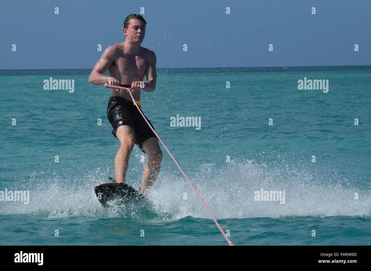 Young man being pulled up on a wakeboard Stock Photo - Alamy