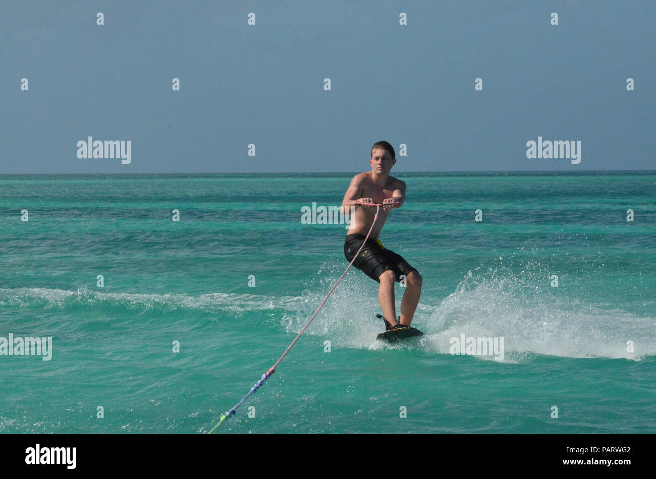 Wakeboarding guy in black swim trunks in Aruba Stock Photo - Alamy