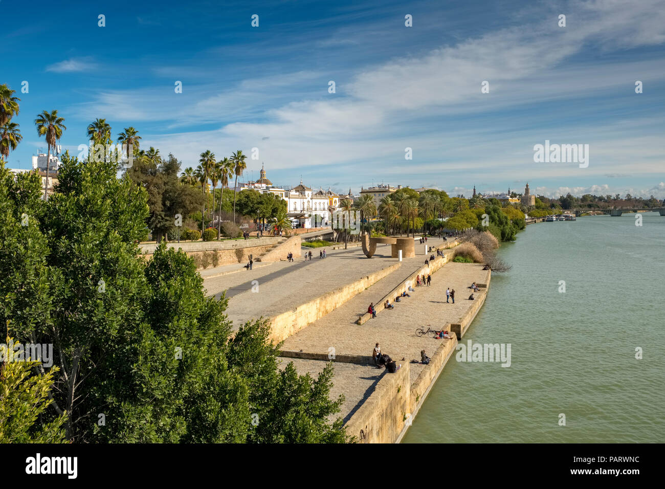 Seville, the Guadalquivir river waterfront with people in summer, Spain ...