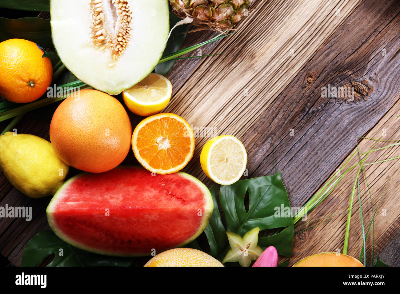 Tropical fruit. Assortment of tropical fruits with leaves of palm trees ...