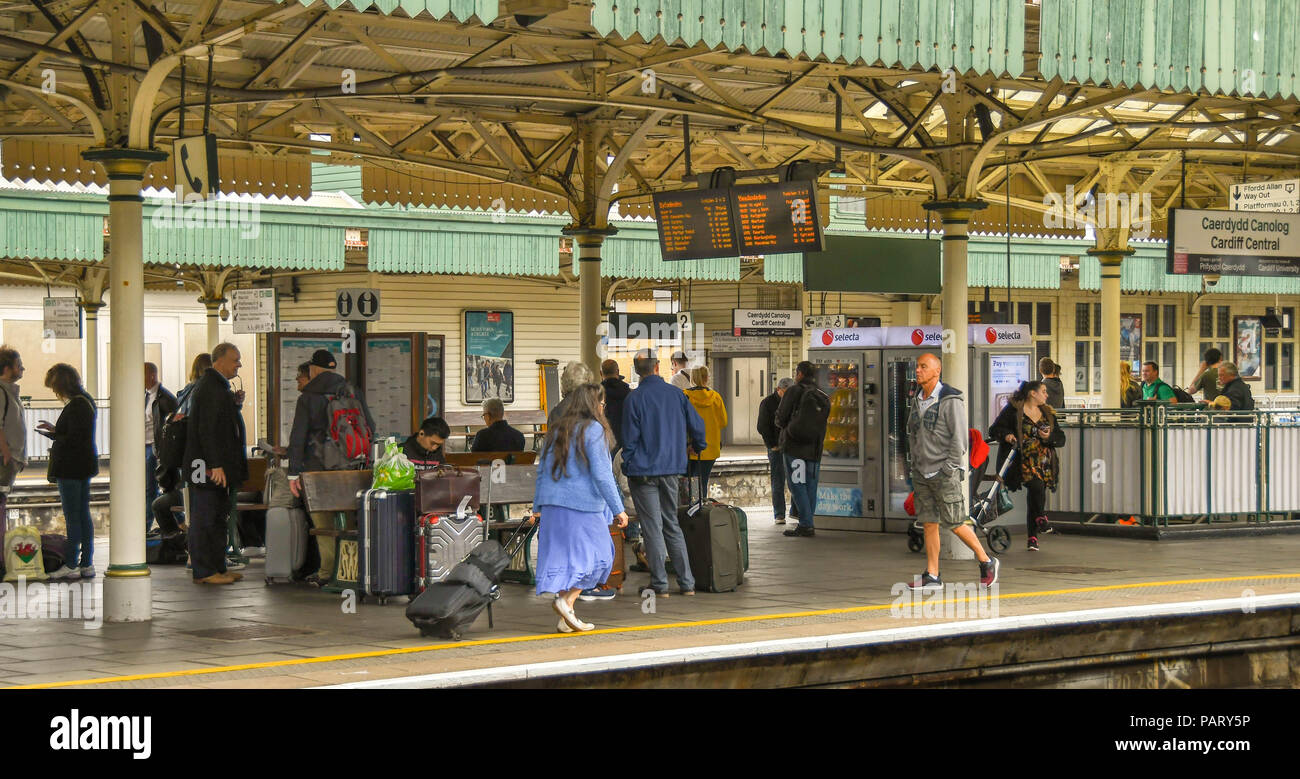Passengers waiting for their train on a platform in Cardiff Central ...