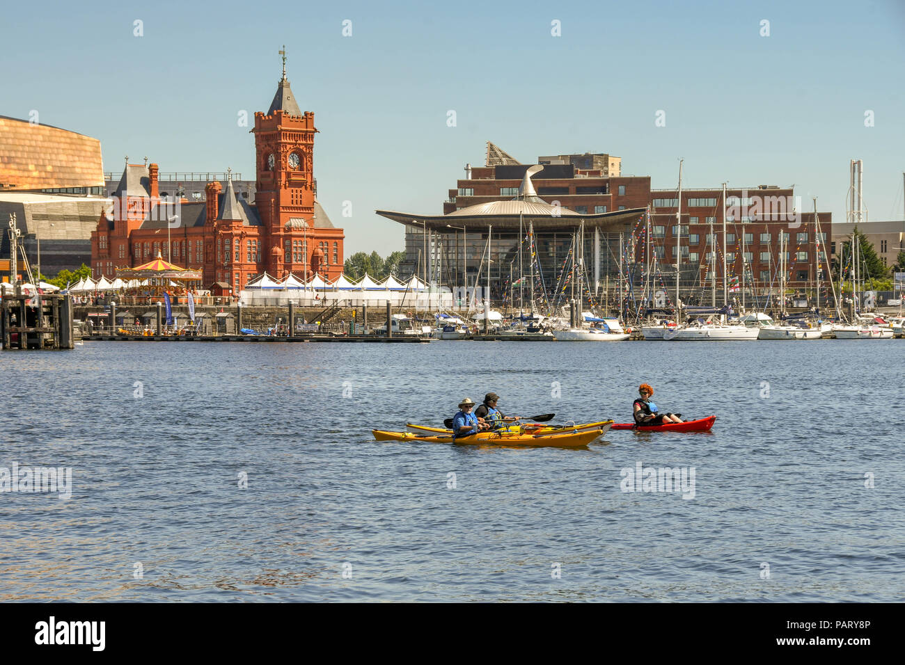 Three people in kayaks paddling on calm water in Cardiff bay Stock ...