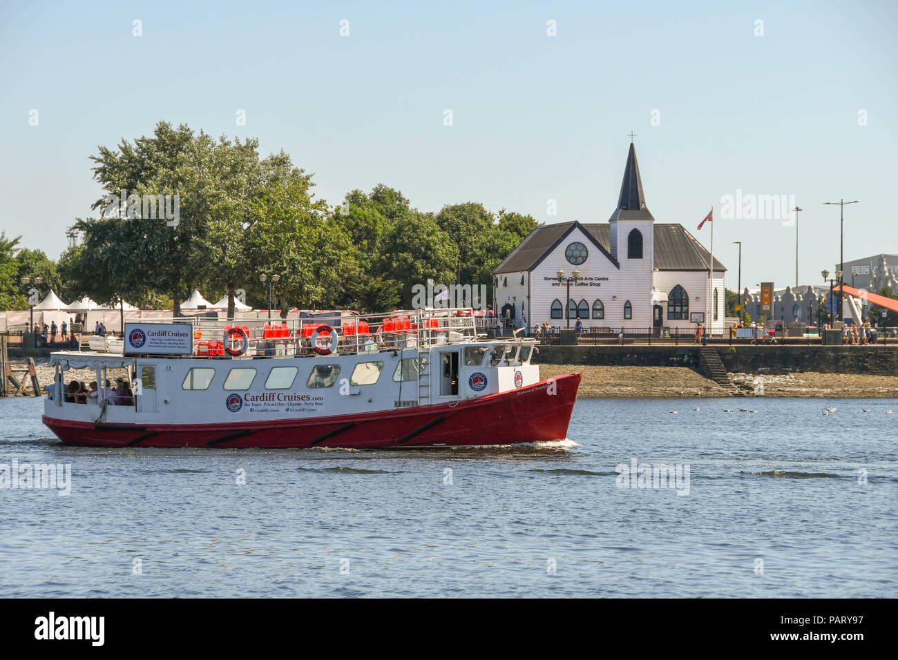 Small passenger ferry taking passengers across Cardiff Bay passing the ...
