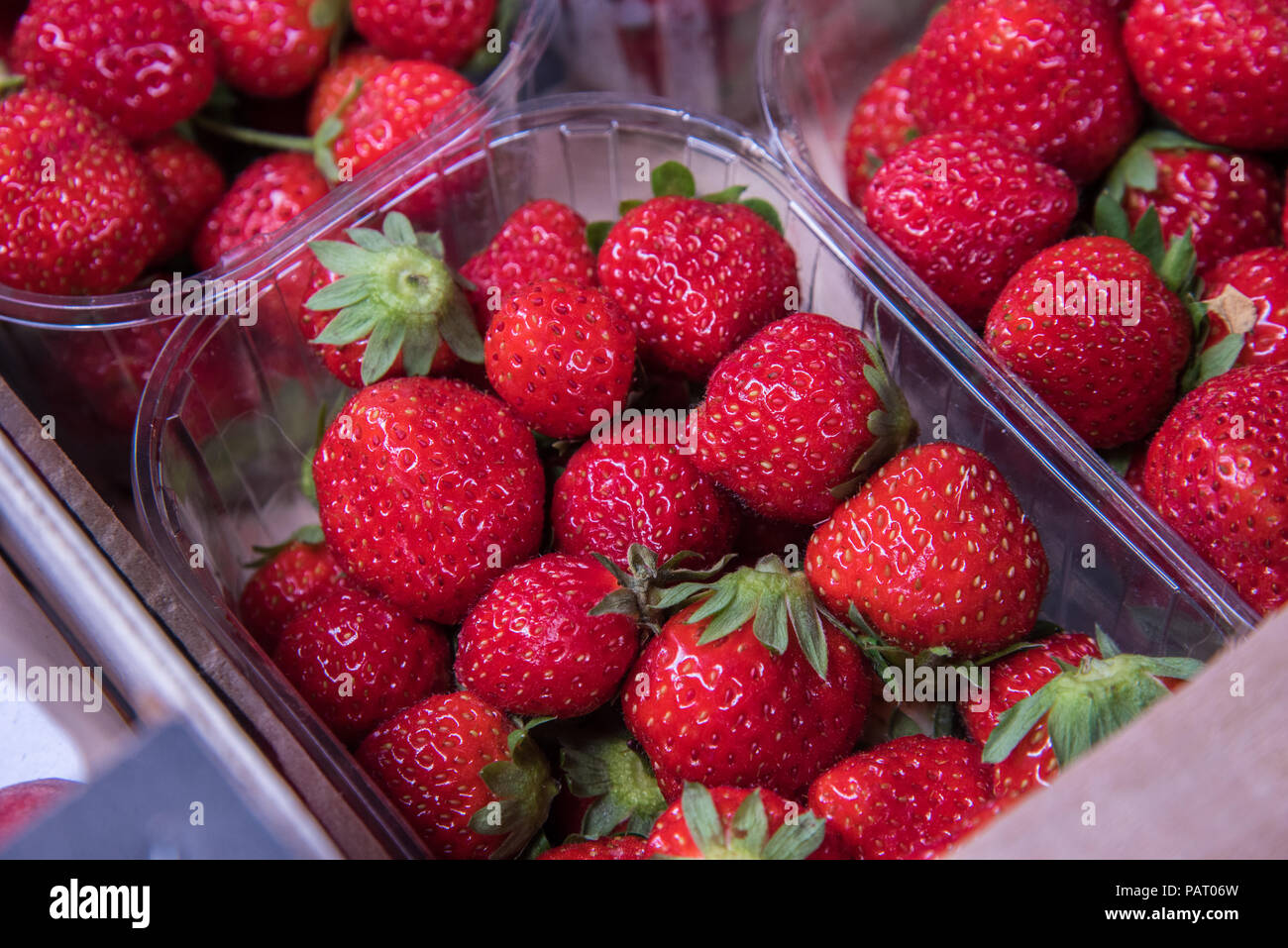 Fresh Strawberries, in a plastic box, on display in a fresh food market ...