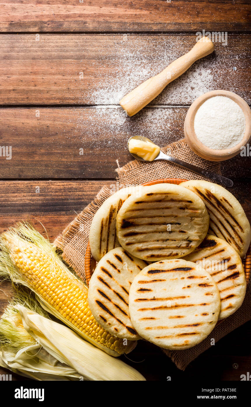 View from above of wooden rustic table with several ground corn Arepas ...