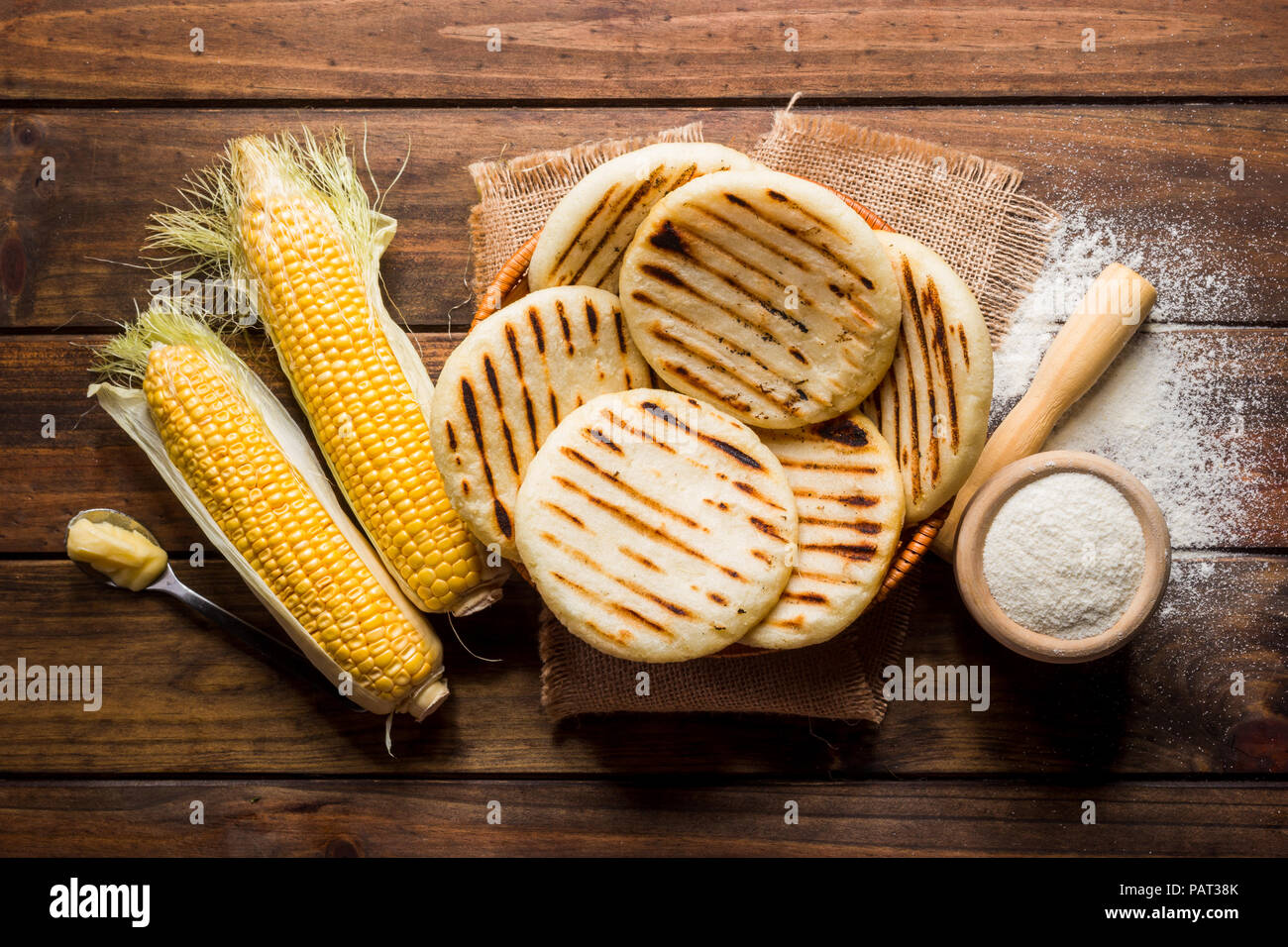 View from above of wooden rustic table with several ground corn Arepas ...
