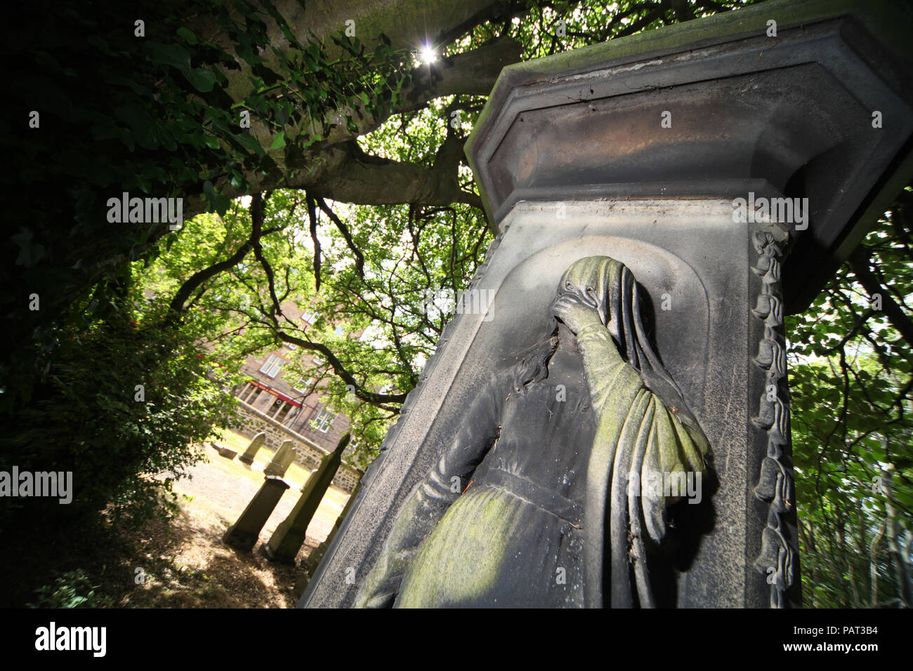 A gravestone with the figure of an angel covering their eyes stands ...