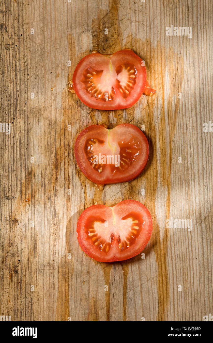 Sliced tomatoes on wood background Stock Photo - Alamy