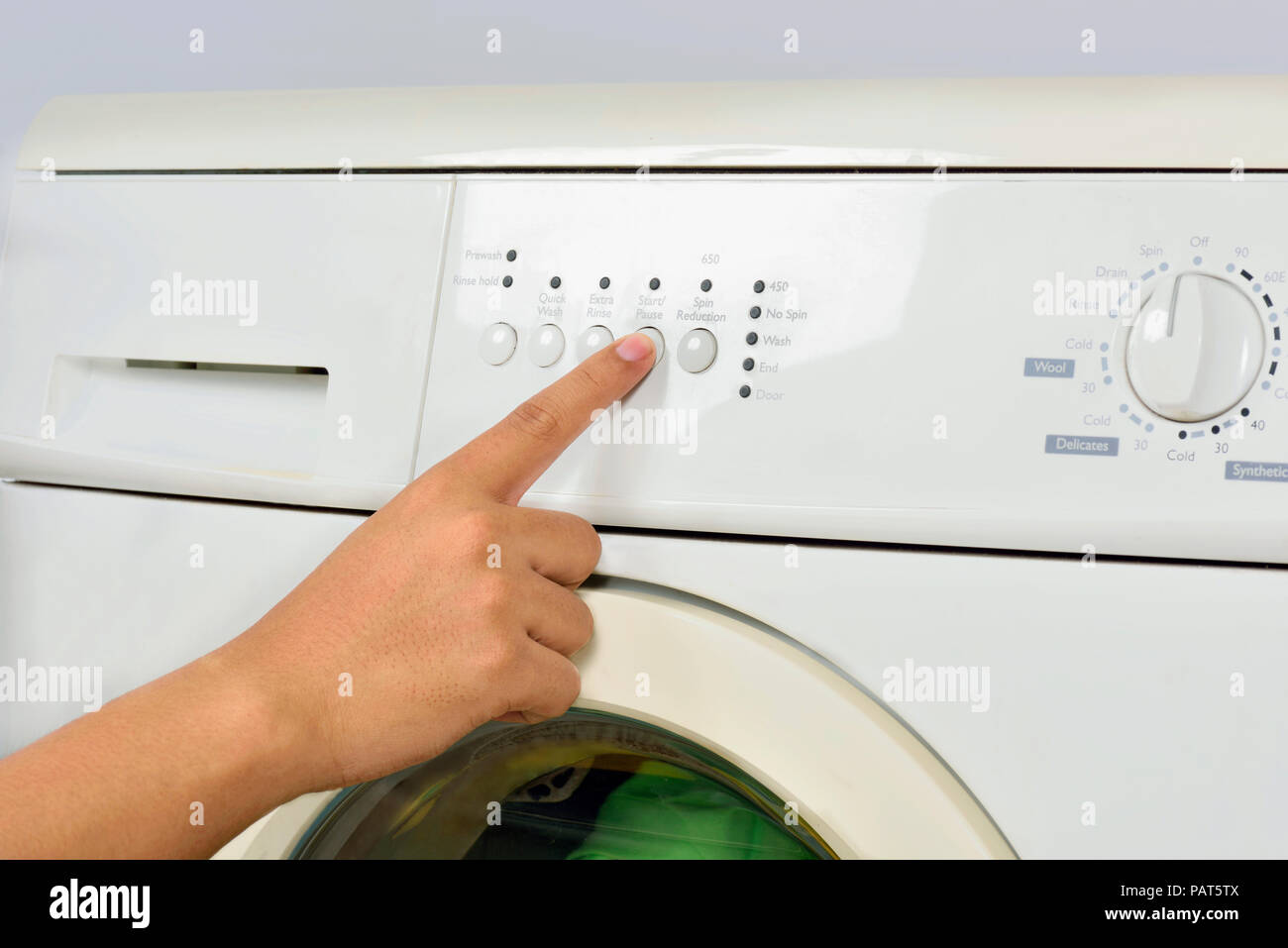 Closeup of hand push the button on washing machine isolated over white ...