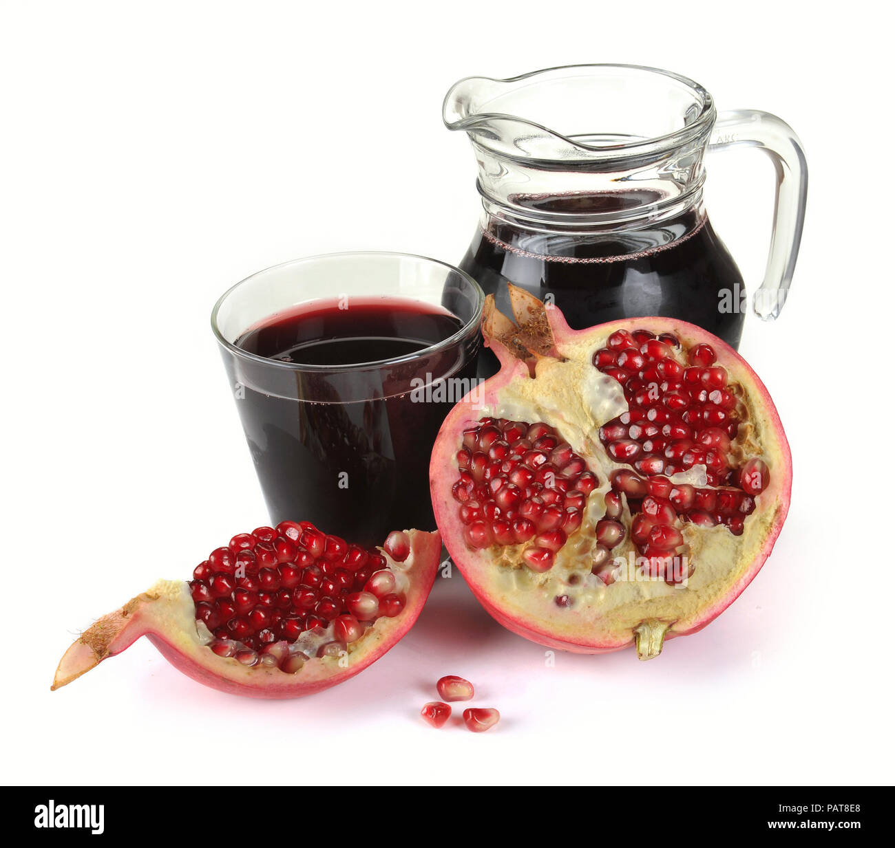 Jug of juice and ripe piece grenade on white background Stock Photo - Alamy