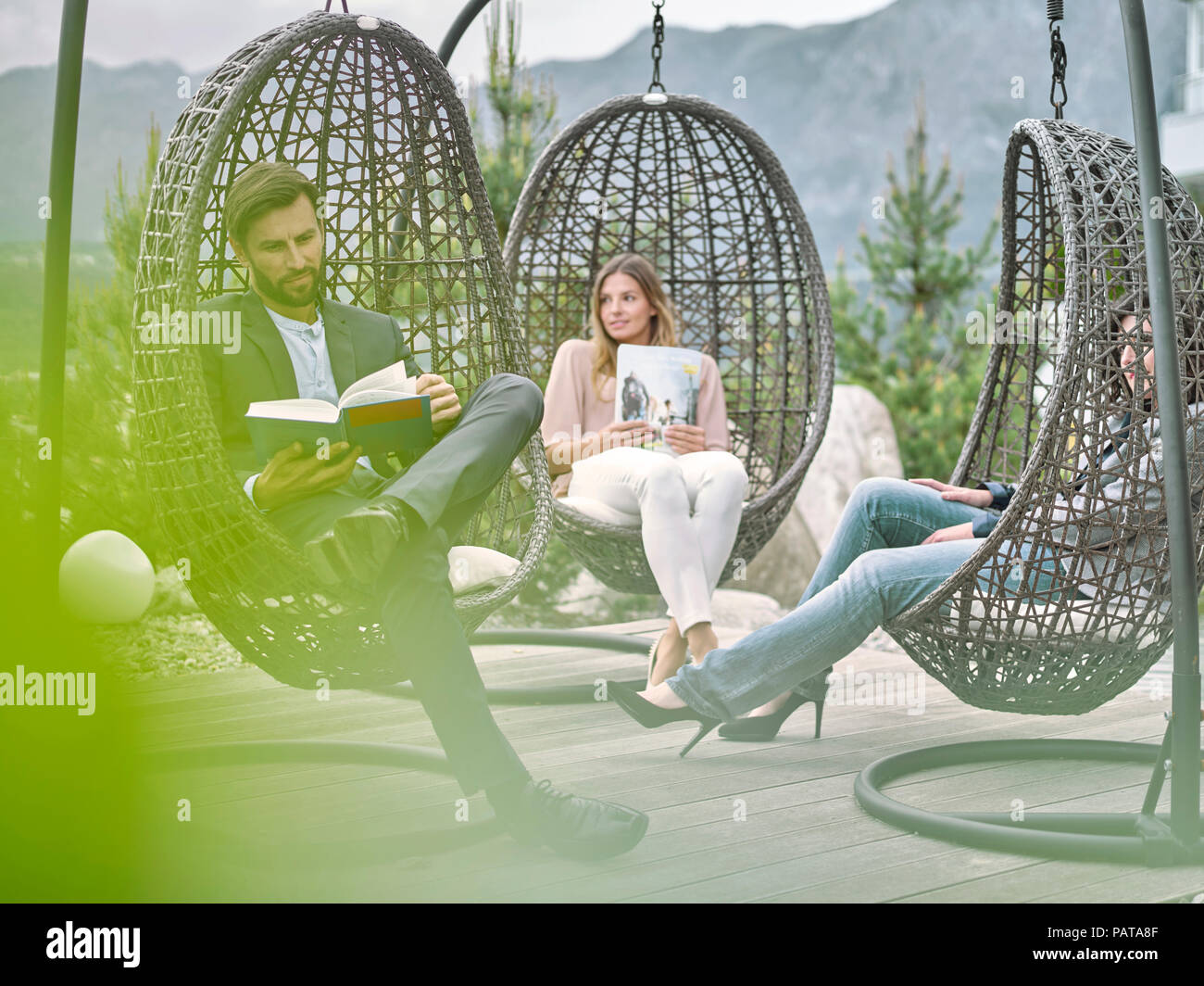 Colleagues having a break sitting in hanging chairs Stock Photo - Alamy