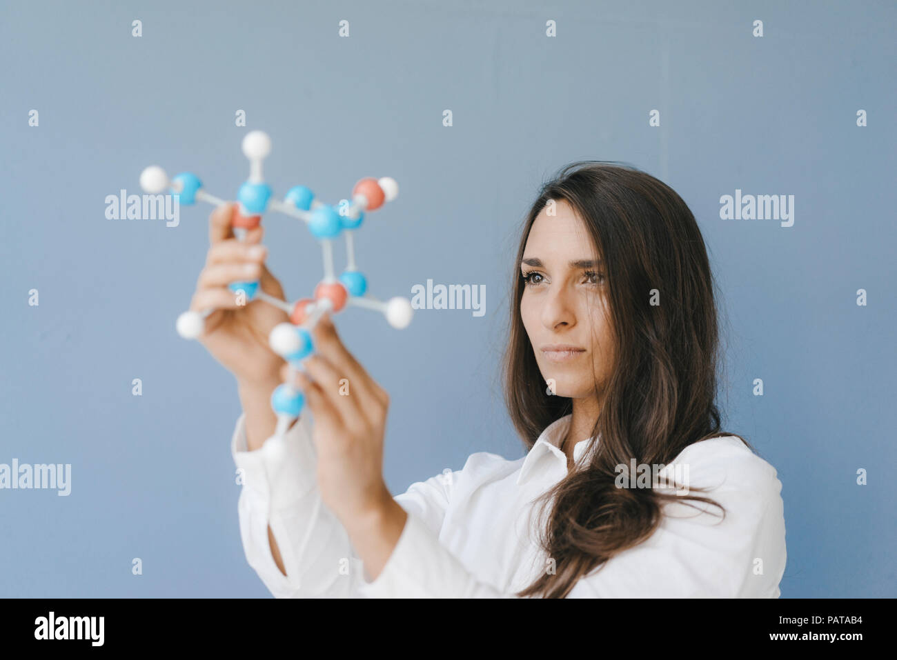 Female scientist holding molecule model, looking for solutions Stock ...