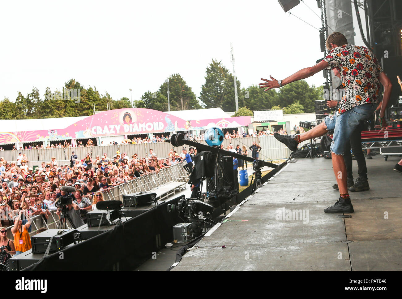 Peter Crouch kicks footballs from the stage into the audience and ...