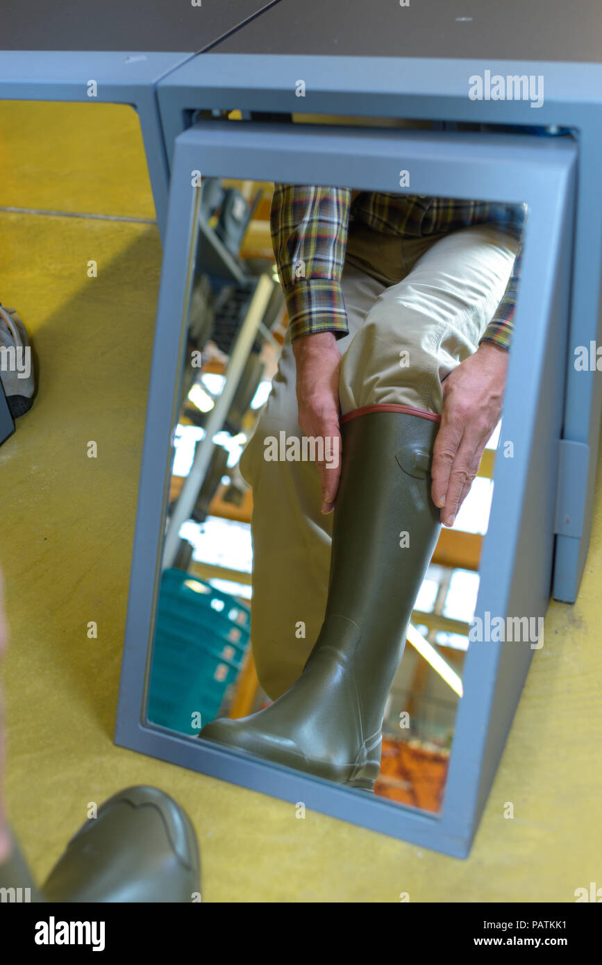 customer trying rubber boots in the shop Stock Photo - Alamy
