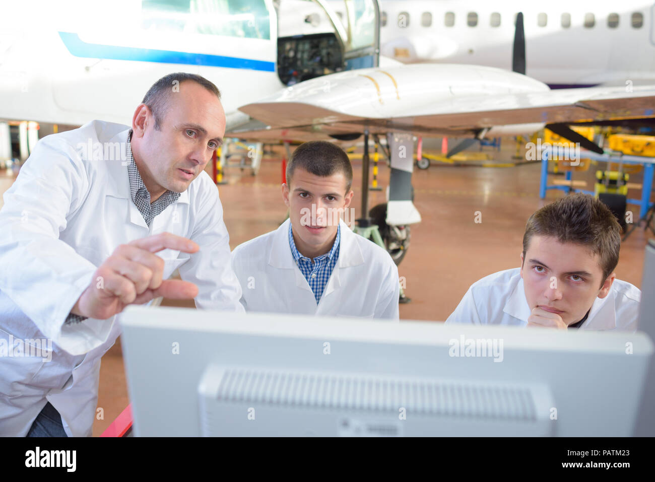 team of aircraft engineers repairing parts of jet Stock Photo - Alamy