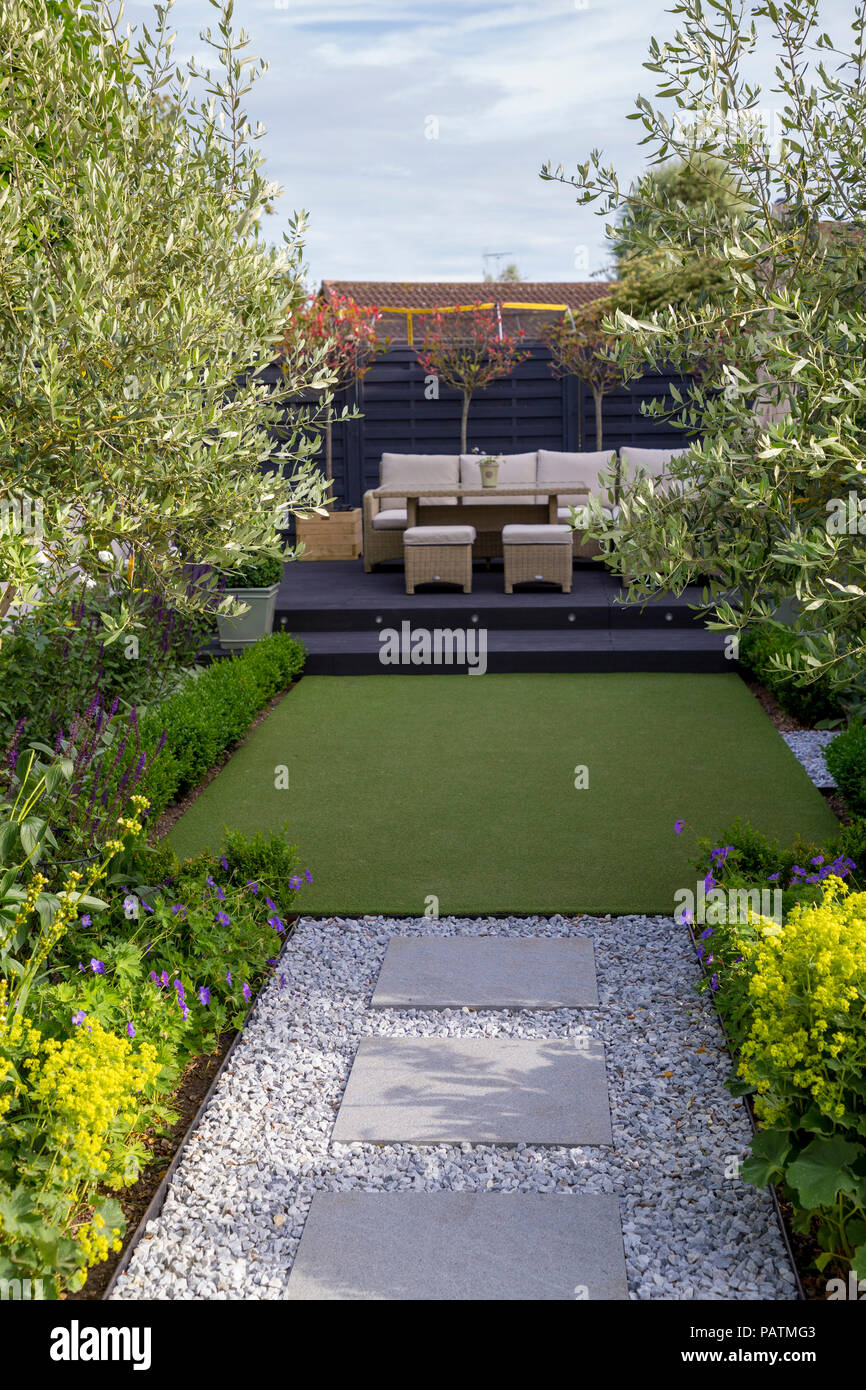 View past Olea europaea trees to the golf putting lawn and decking area ...