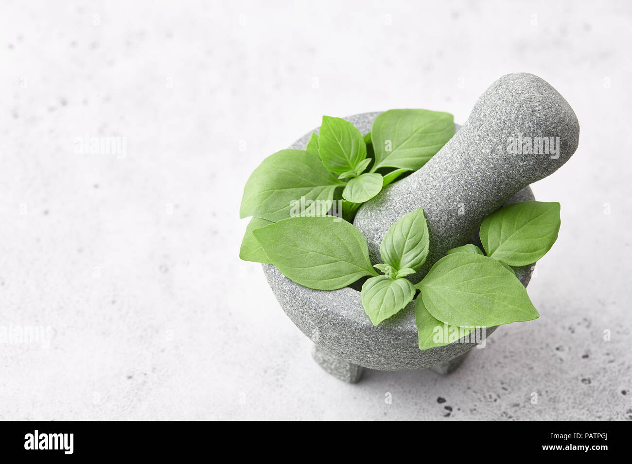 Fresh green basil leaves in gray stone mortar on white background Stock ...