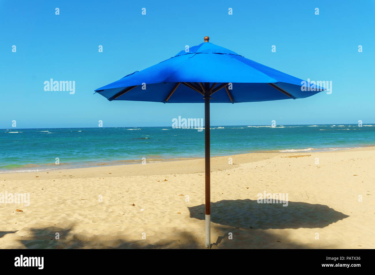 outdoor large blue sun umbrella on the beach with reflection on the ...