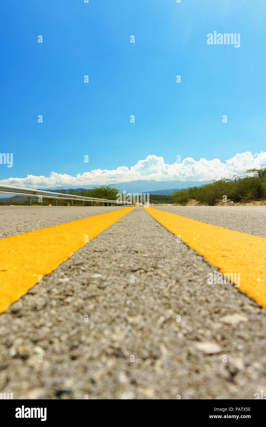 yellow dividing line on asphalt road on blue sky background Stock Photo ...