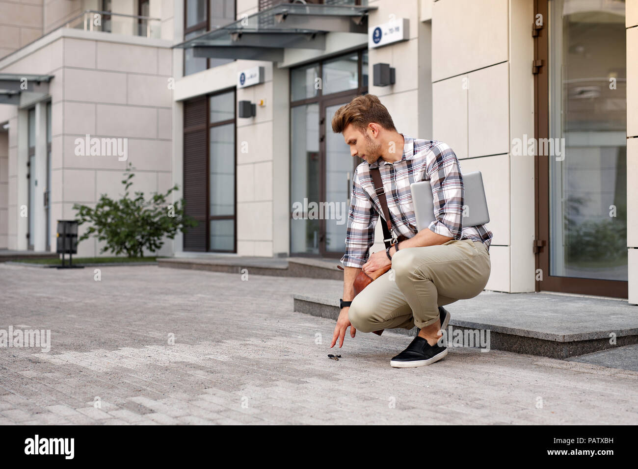 Good looking nice man dropping his keys Stock Photo - Alamy