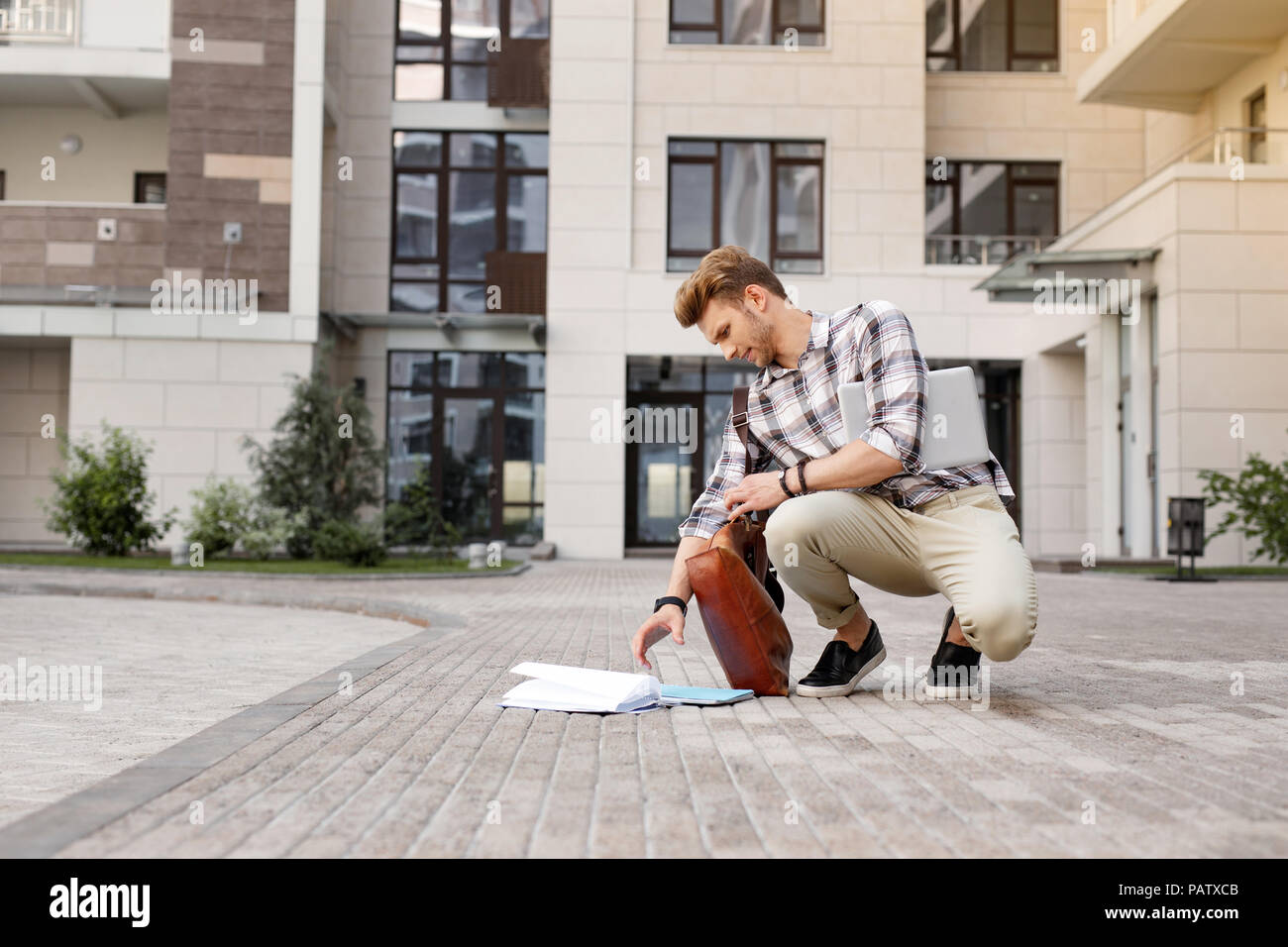 Cheerless sad man taking his notebooks Stock Photo - Alamy