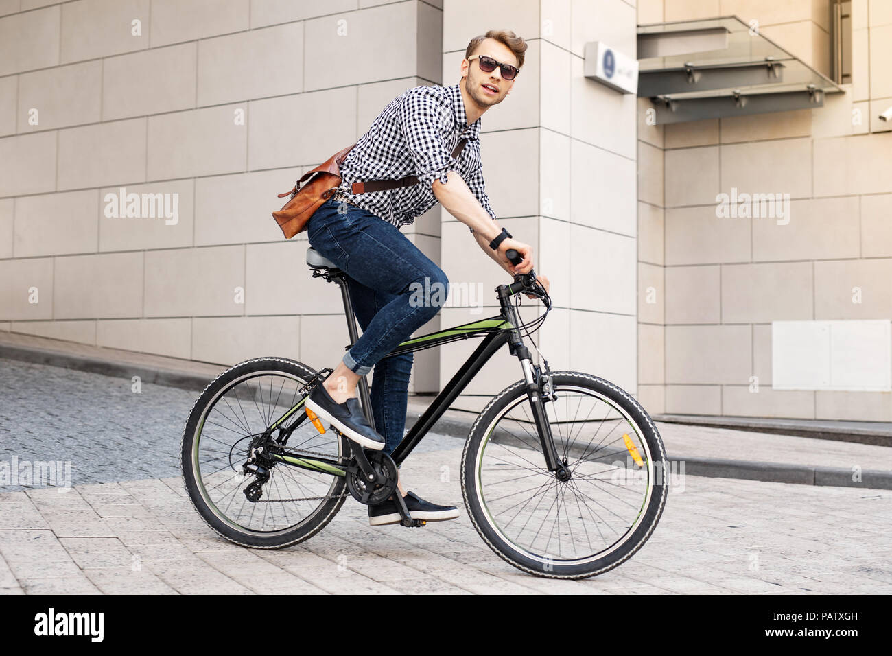 Smart handsome man riding a bike in the city Stock Photo - Alamy