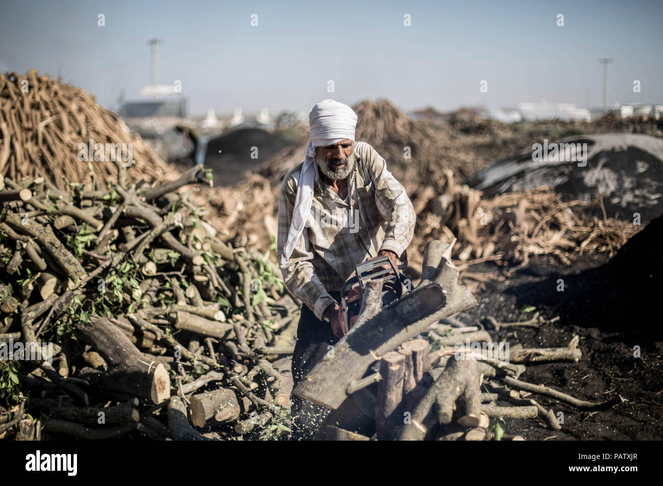 A Palestinian worker seen working on the wood used in the extraction ...