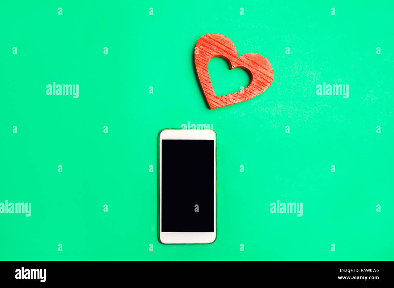 dependence on social networks. phone smartphone and heart on a green ...