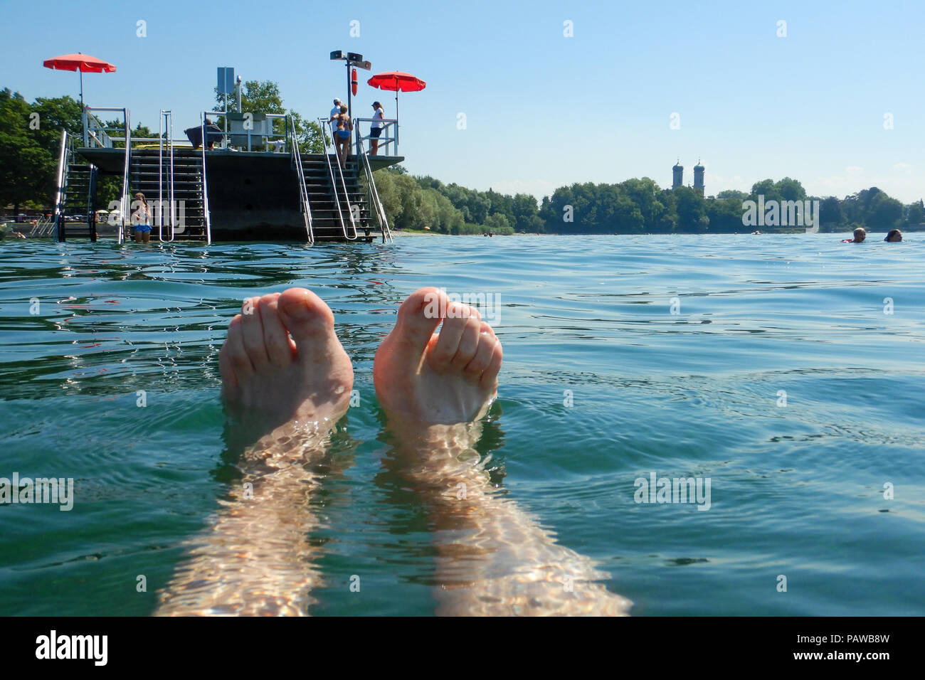 Germany, Friedrichshafen. 25th July, 2018. A bathing guest lets his ...