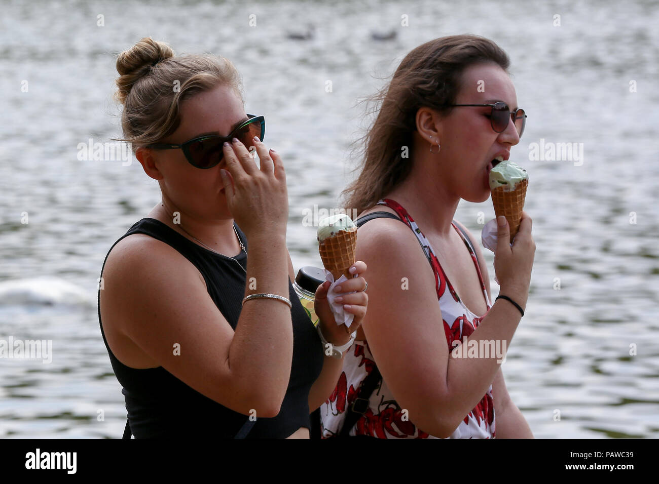 Hyde Park. London. UK 25 June 2018 - Women eating ice cream in Hyde Park on a very hot and humid ...