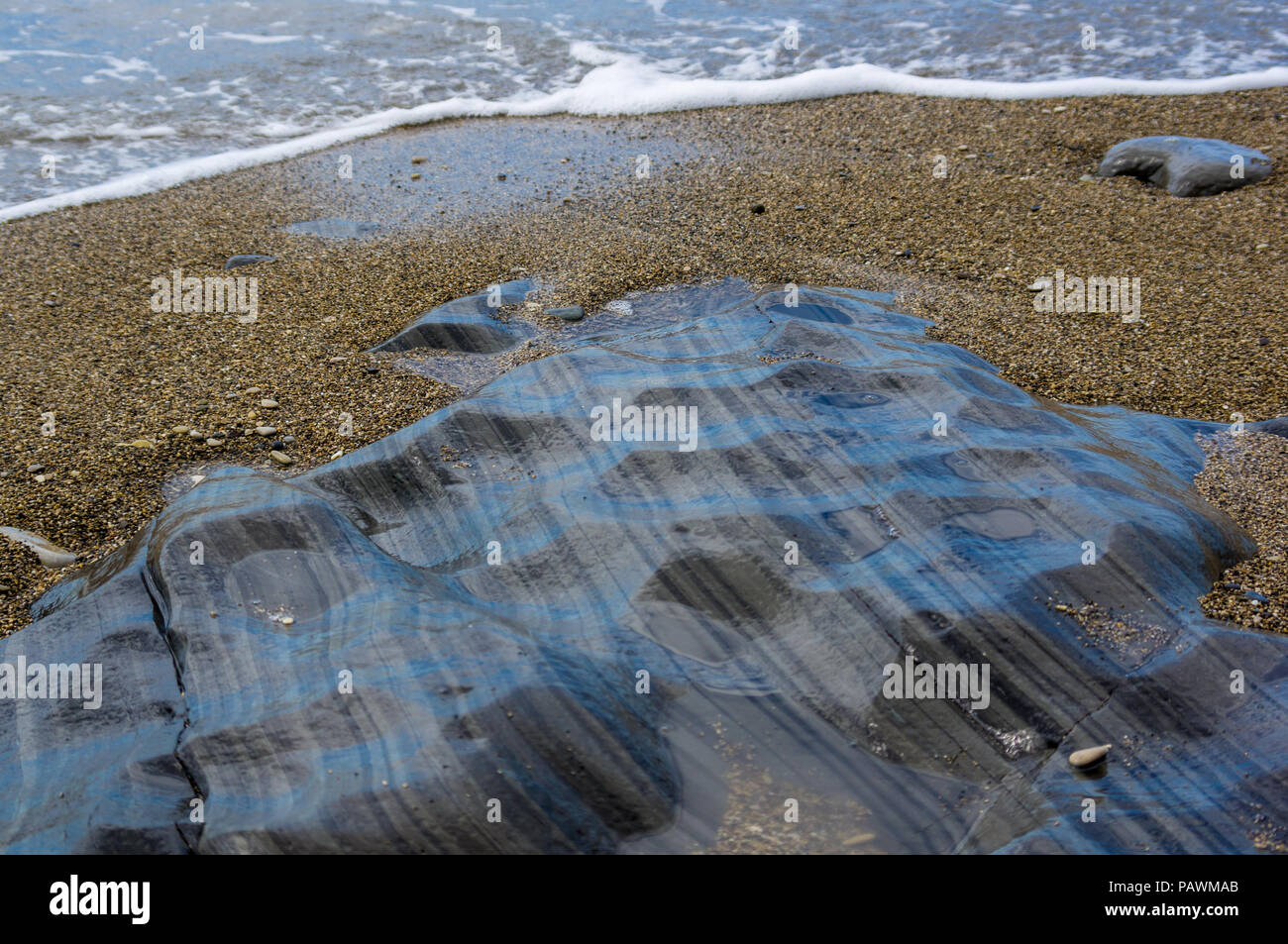 pebble stones on the sea beach on a warm summer day, the rolling waves ...