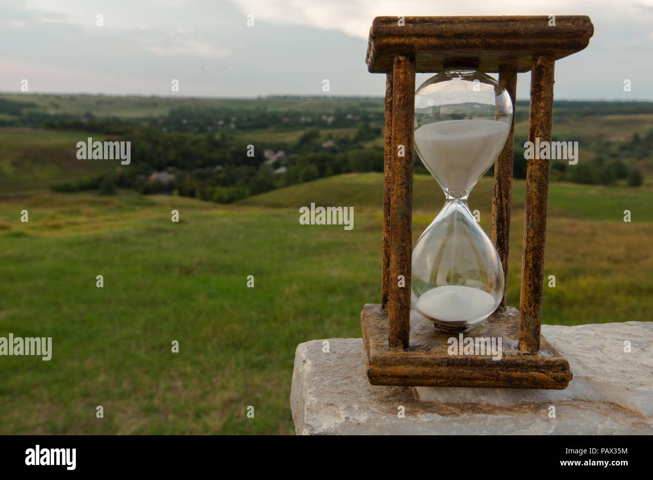 hourglass as a symbol of the passing time stand on a white stone marble ...