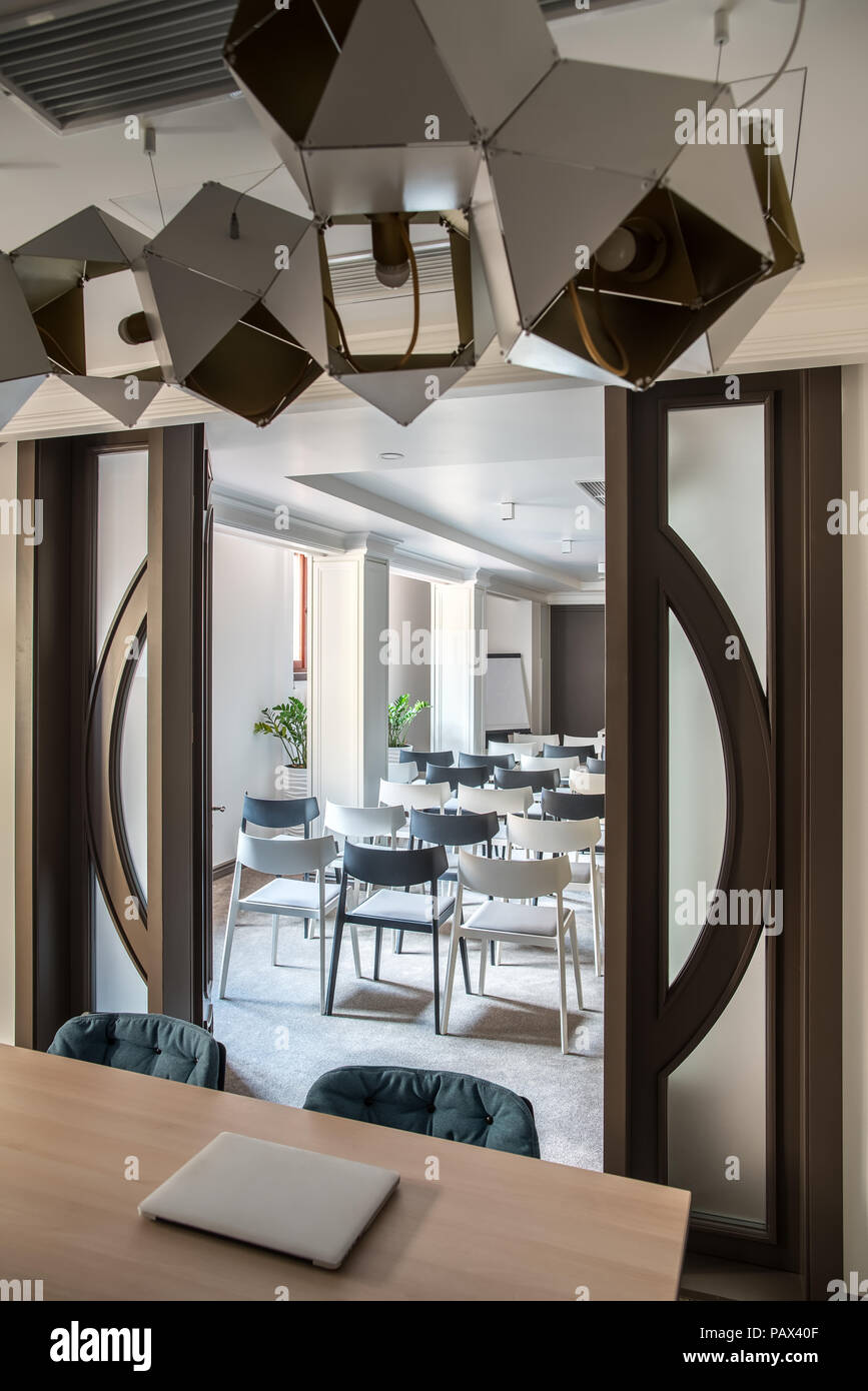 Large conference hall with white walls and a gray floor. There are many ...