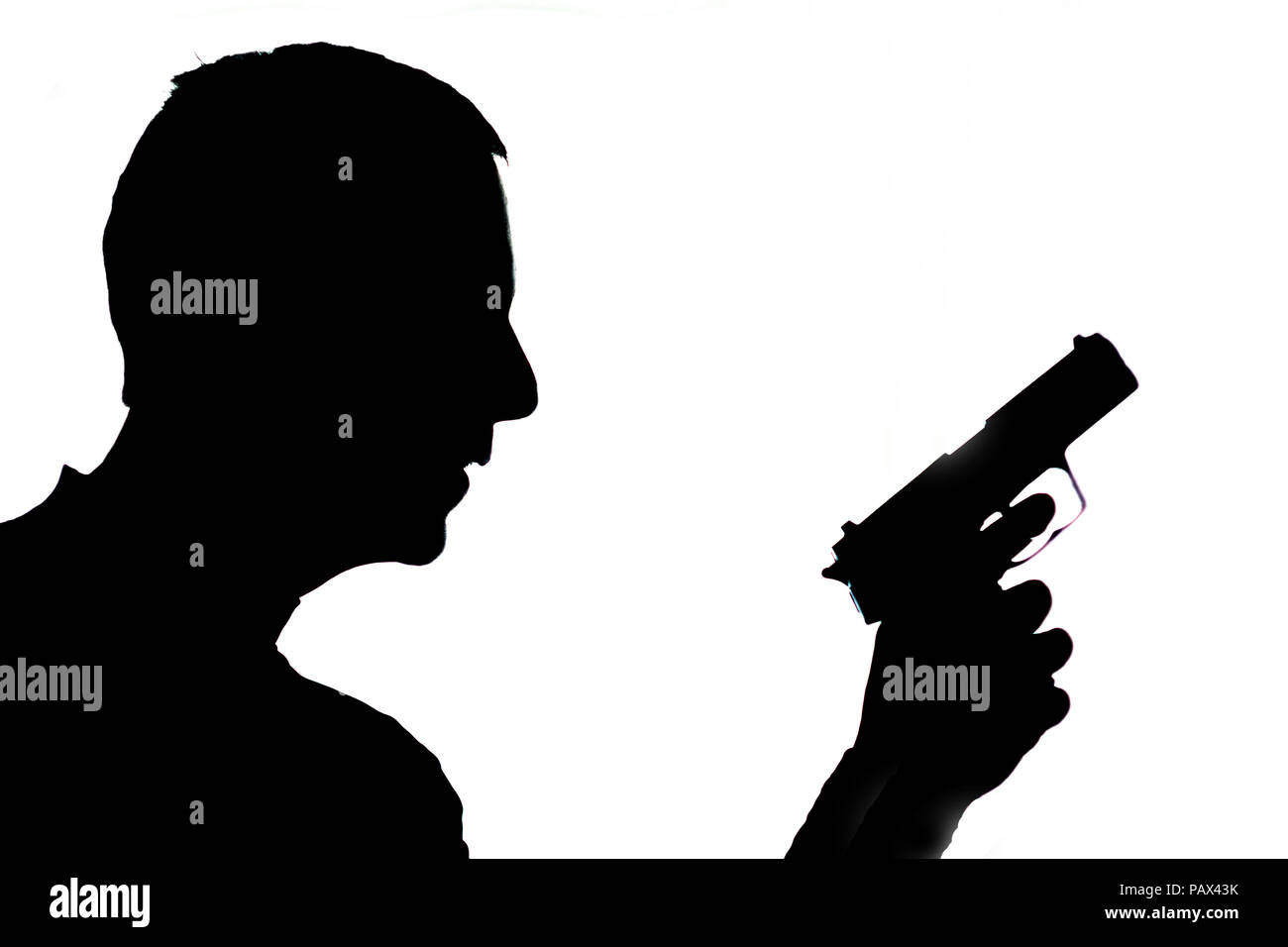 Man in a position of alert with a gun in his hand Stock Photo - Alamy