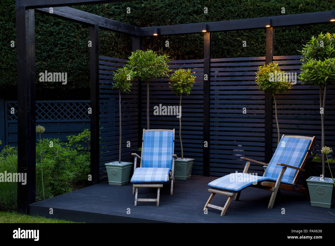 Cube pergola with downlighting on seating area and potted Bay tree ...