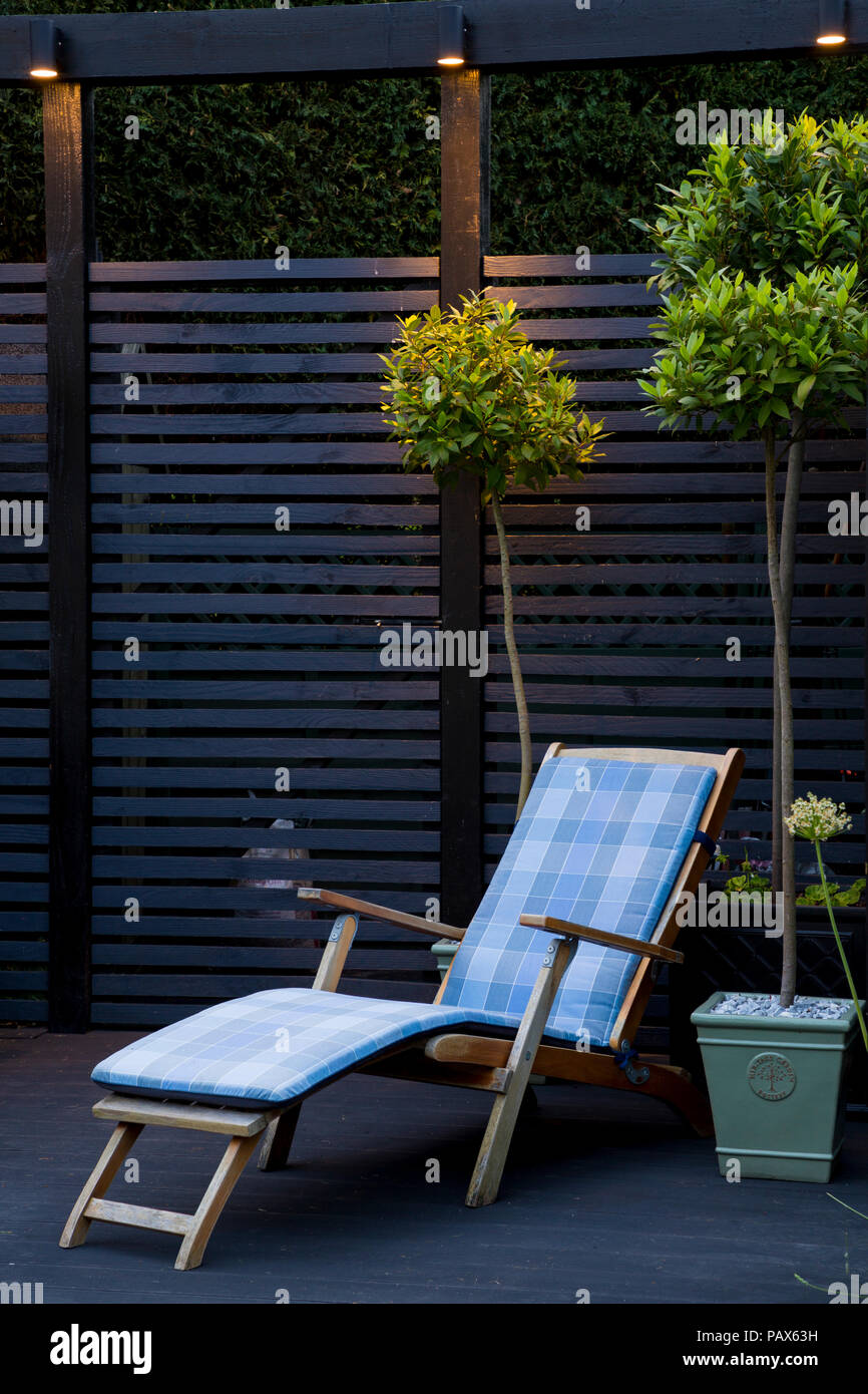 Cube pergola with downlighting on seating area and potted Bay tree ...