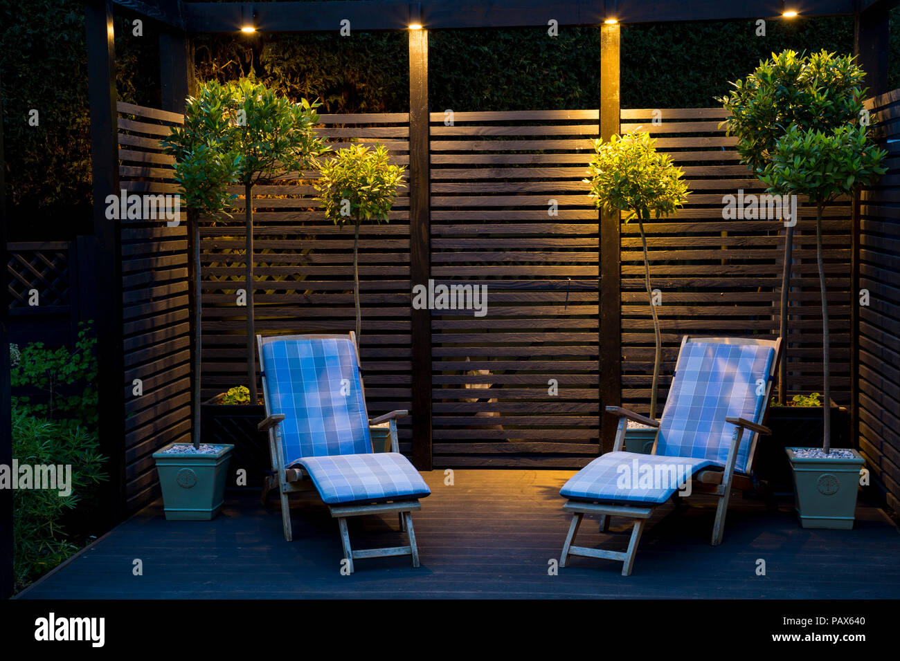 Cube pergola with downlighting on seating area and potted Bay tree ...
