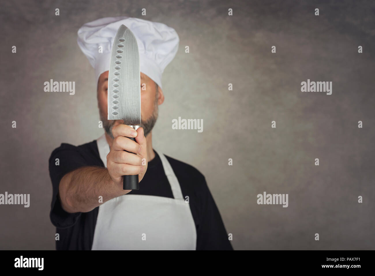 man holding knife on gray background Stock Photo - Alamy
