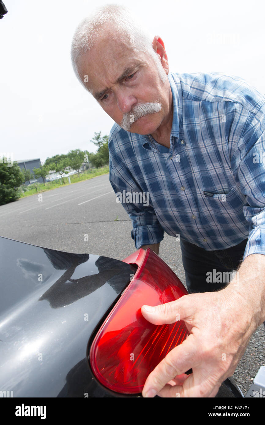 old man installs tail light on the vehicle Stock Photo - Alamy