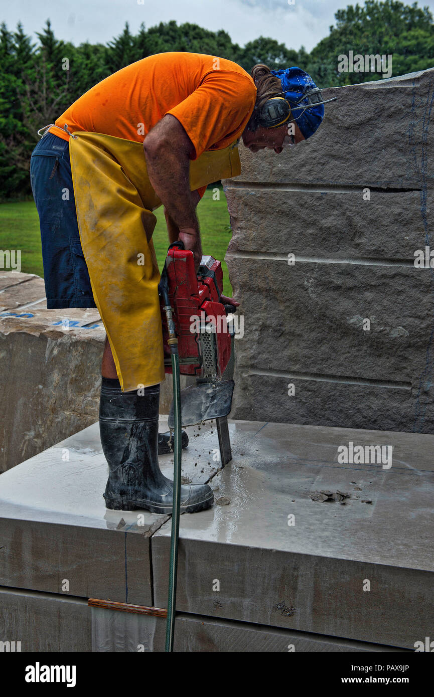 UNITED STATES: July 24, 2018: Sculptor Gary Colson cuts a large slab of ...