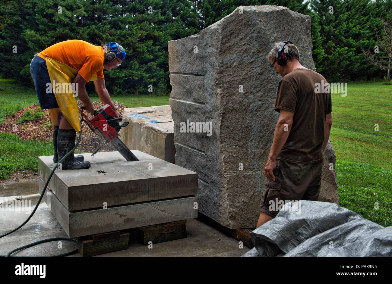 UNITED STATES: July 24, 2018: Sculptor Gary Colson cuts a large slab of ...