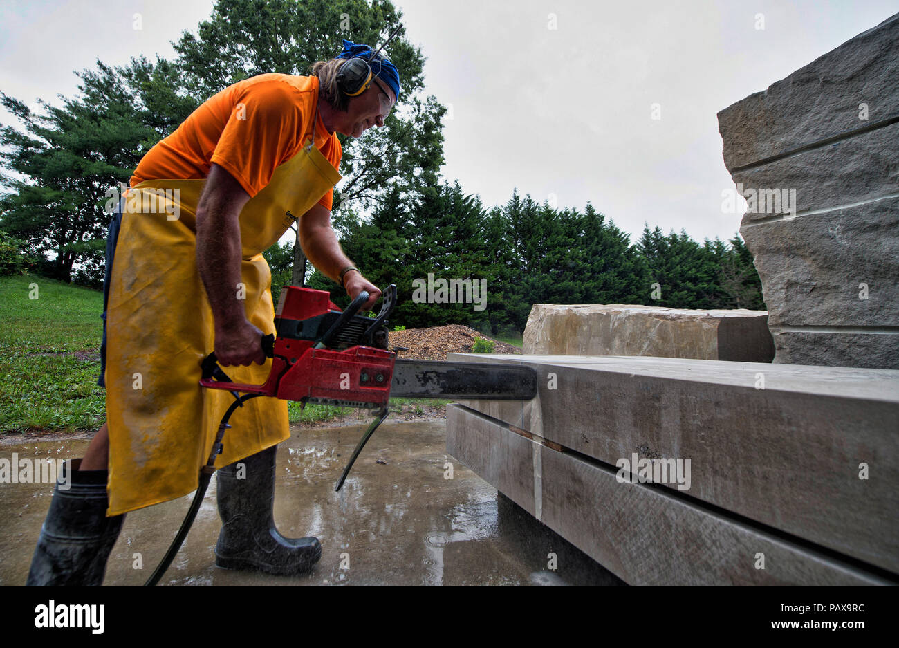 UNITED STATES: July 24, 2018: Sculptor Gary Colson cuts a large slab of ...