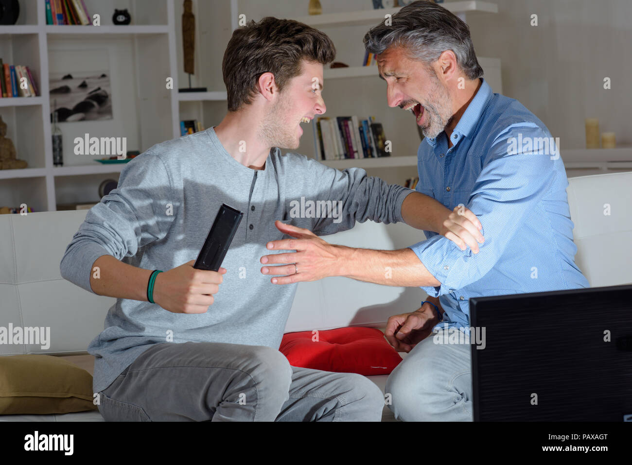 Father and son play fighting over remote control Stock Photo - Alamy