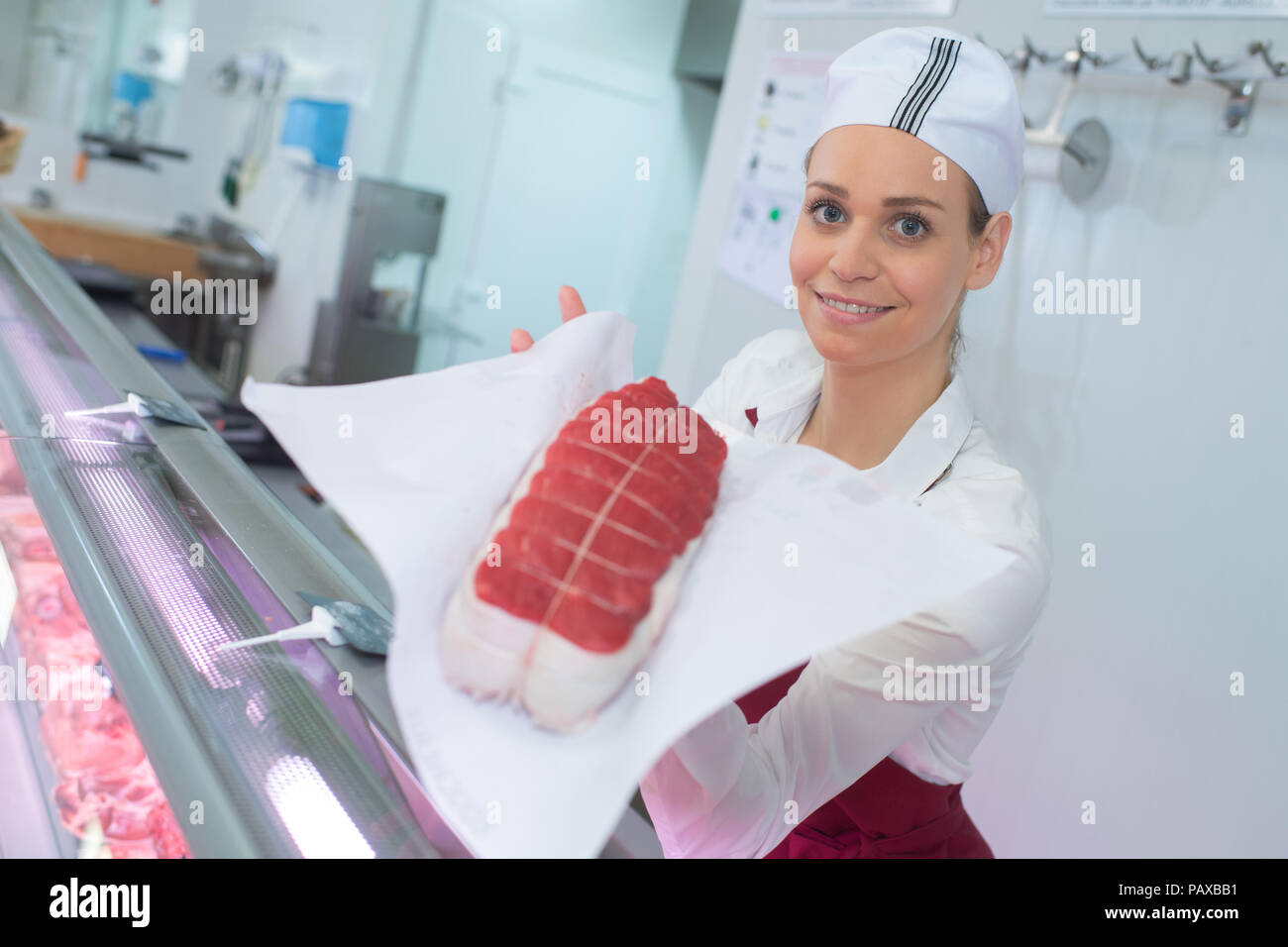 Female butcher showing joint of beef Stock Photo - Alamy