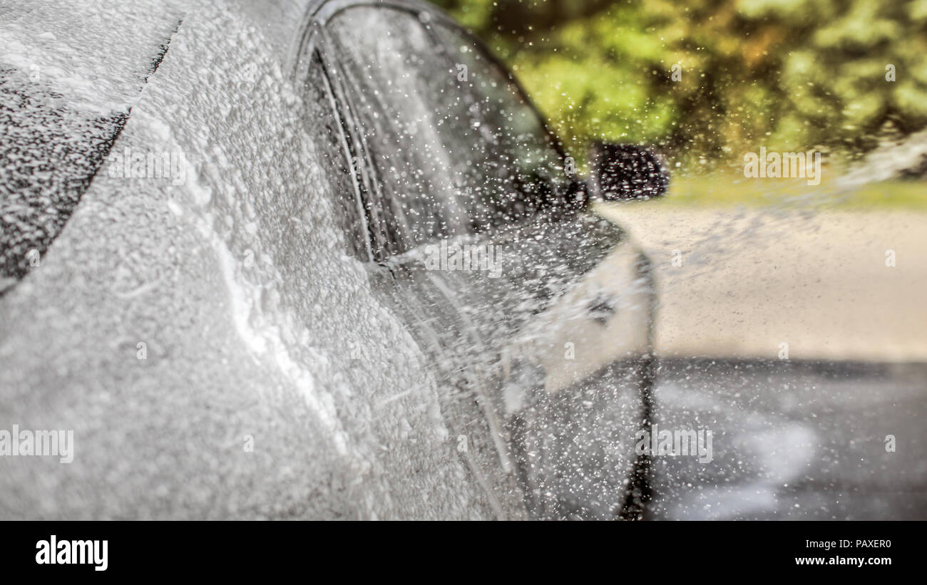 Abstract carwash background - only drops in focus. Car being washed at ...