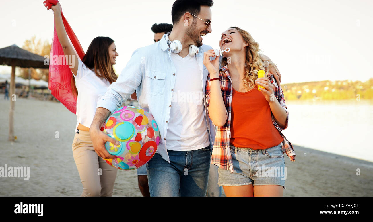Group of happy friends partying on beach Stock Photo - Alamy