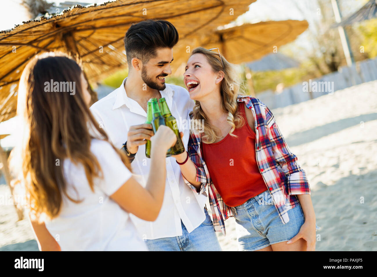 Group of young friends laughing and drinking beer Stock Photo - Alamy