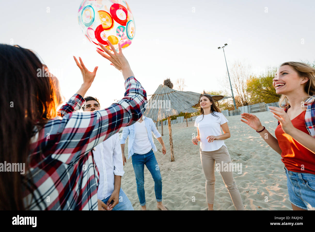 Group of young cheerful friends playing with ball Stock Photo - Alamy