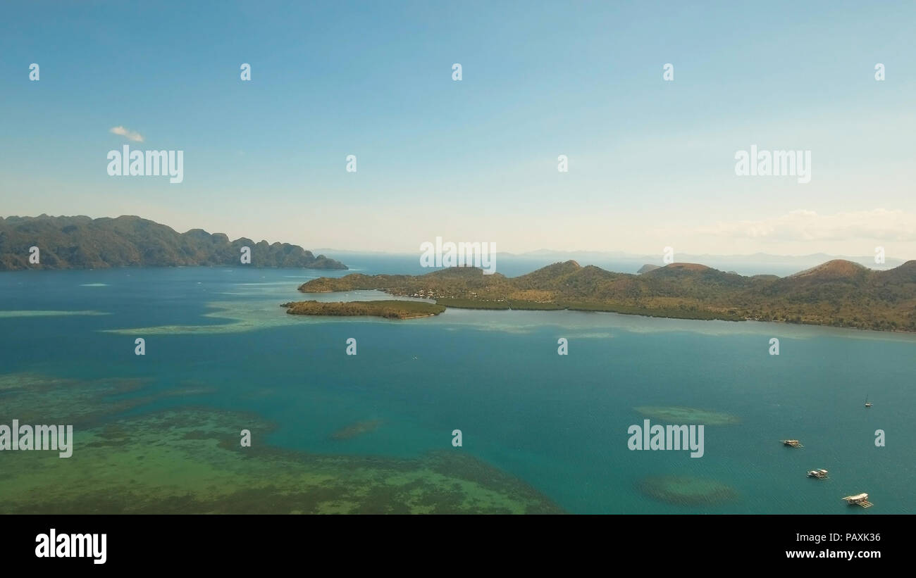 Aerial view: beach, tropical island, sea bay and lagoon, mountains with ...